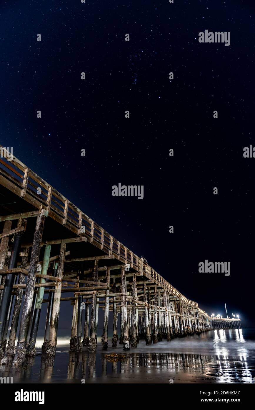 Pier lamps reflect in the Pacific Ocean water under the Ventura Pier ...