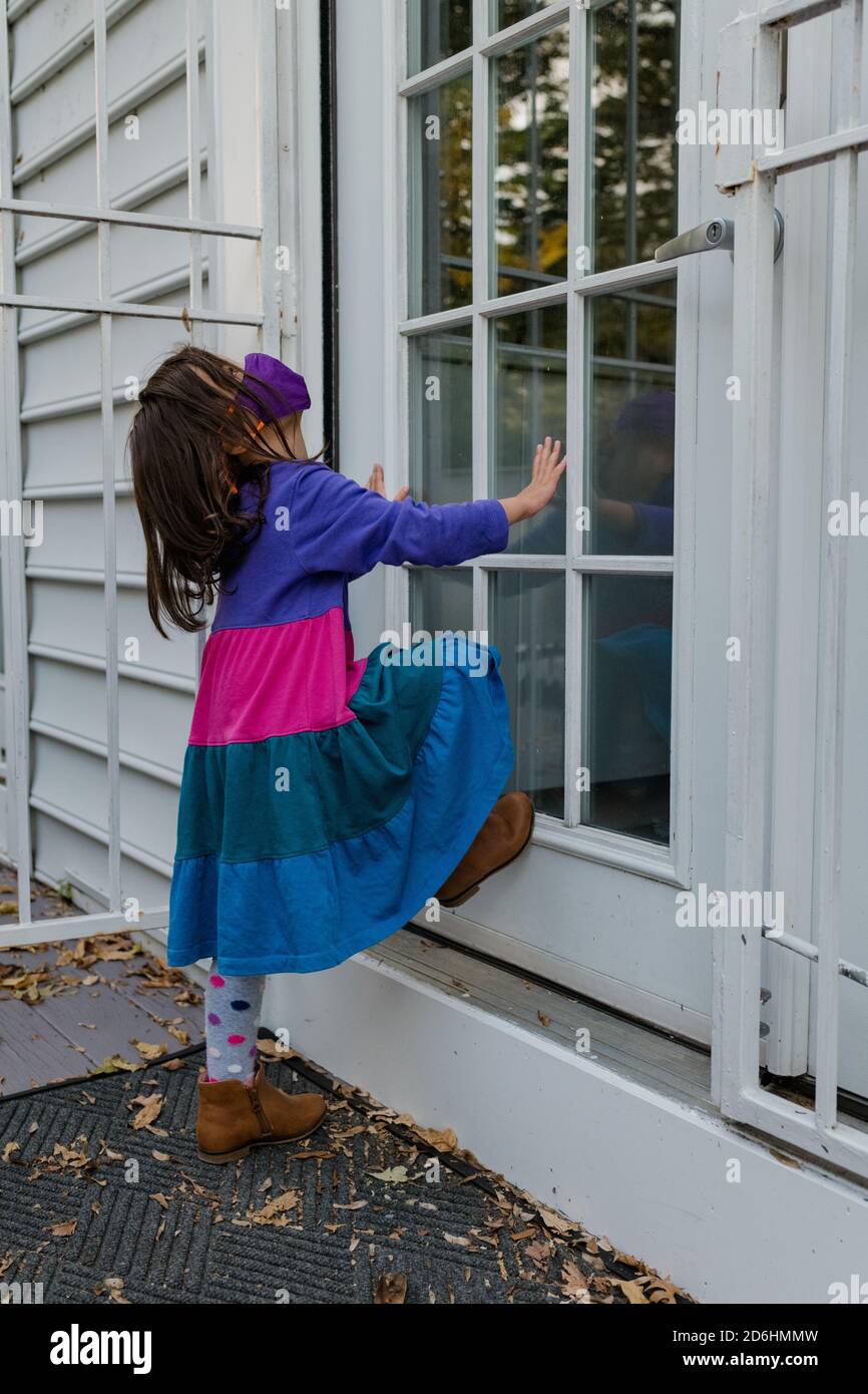 Little girl waiting at door with face mask, impatient Stock Photo - Alamy