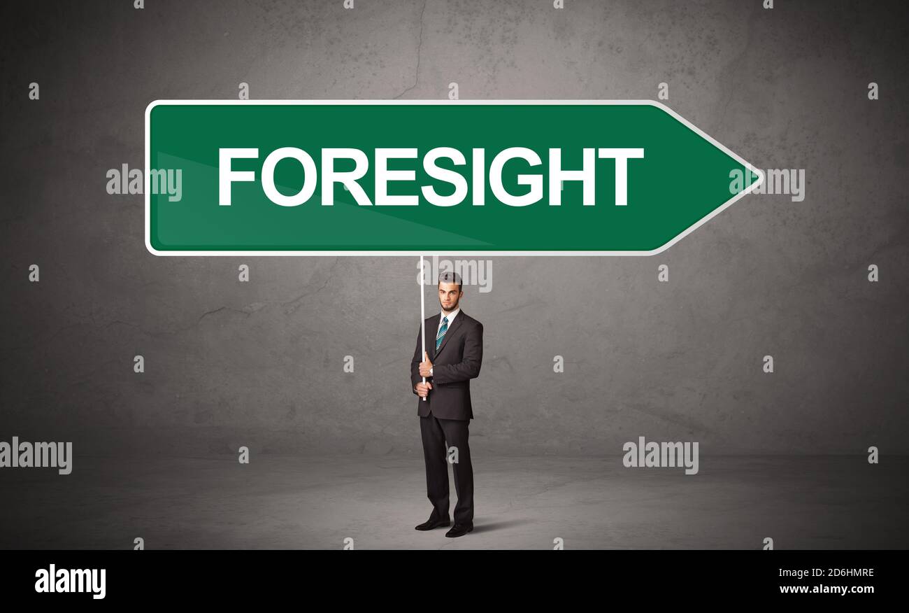 Young business person in casual holding road sign with FORESIGHT ...