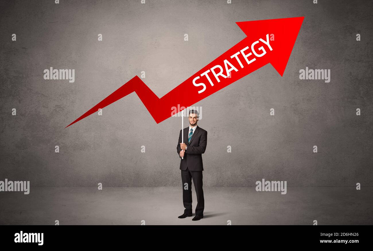 Young business person in casual holding road sign with STRATEGY ...