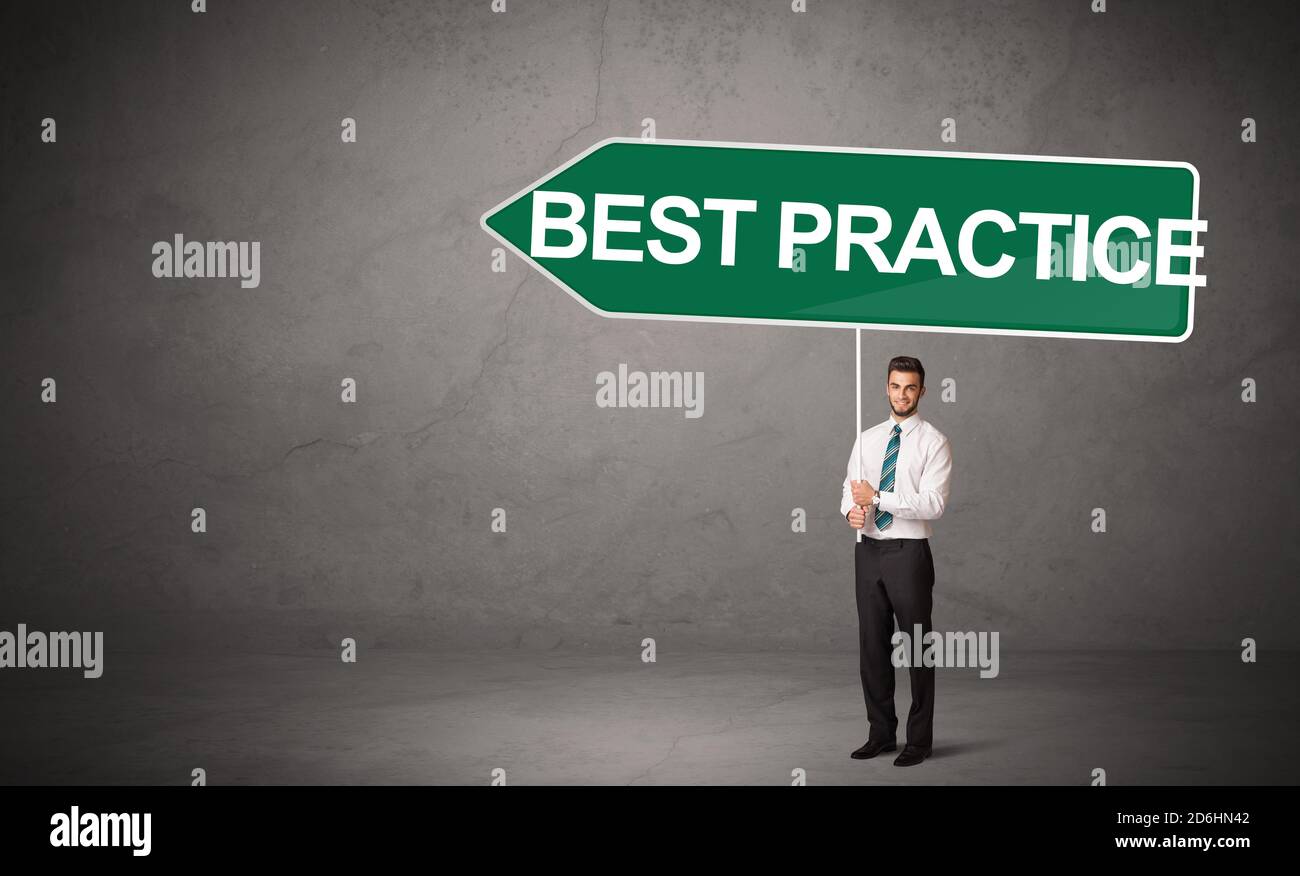 Young business person in casual holding road sign with BEST PRACTICE ...