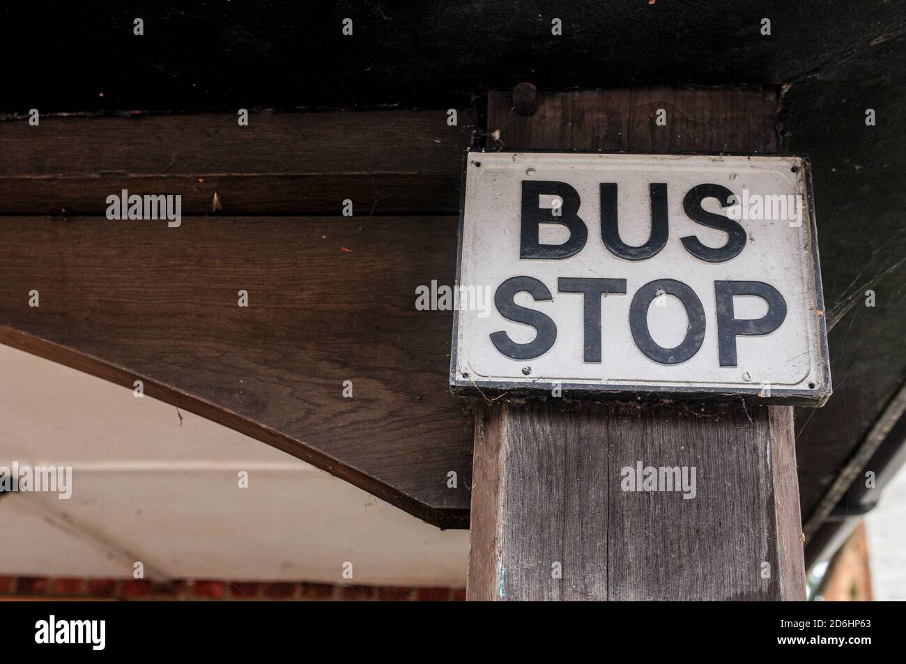 Distinctive bus stop sign attached to wooden post Stock Photo - Alamy
