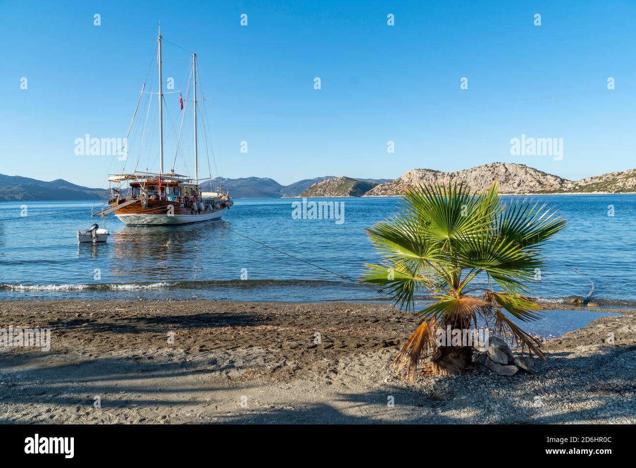 A traditional Turkish gullet boat anchoring at a small bay. Sandy beach ...