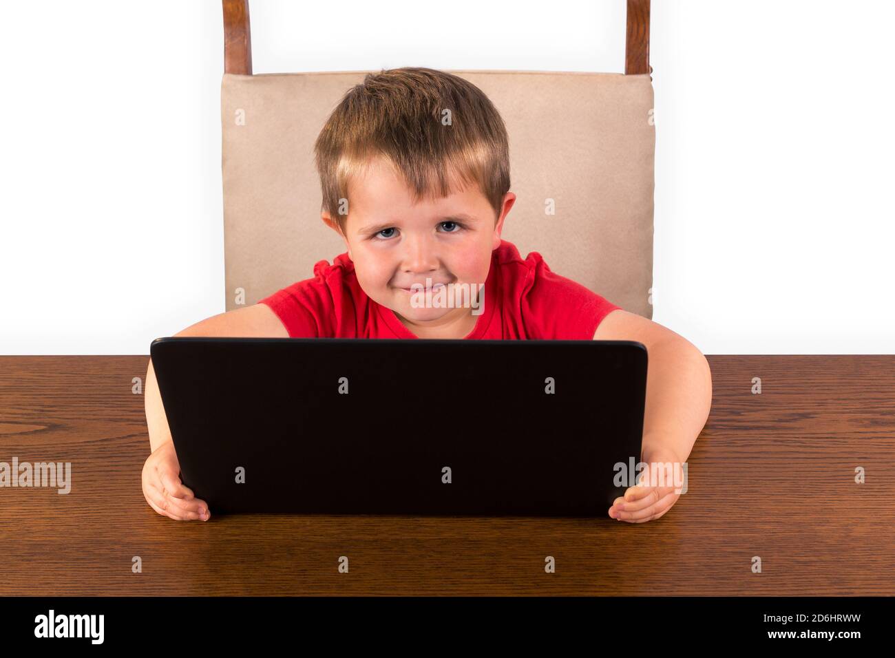 4 year old toddler having fun with a laptop computer looking at camera ...