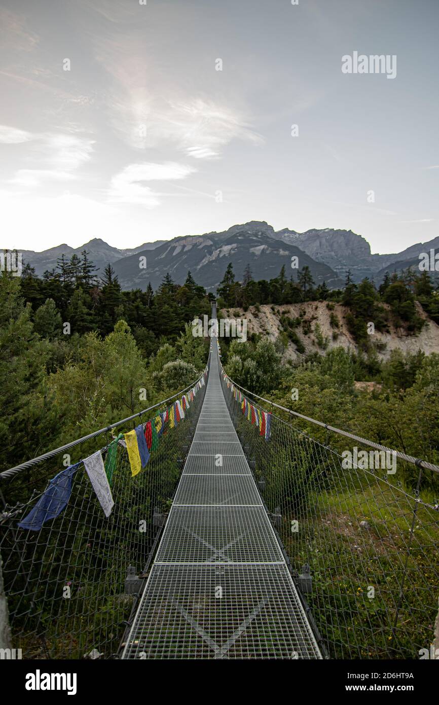 Wooden long footbridge above the deep gorge with a river beach at the ...