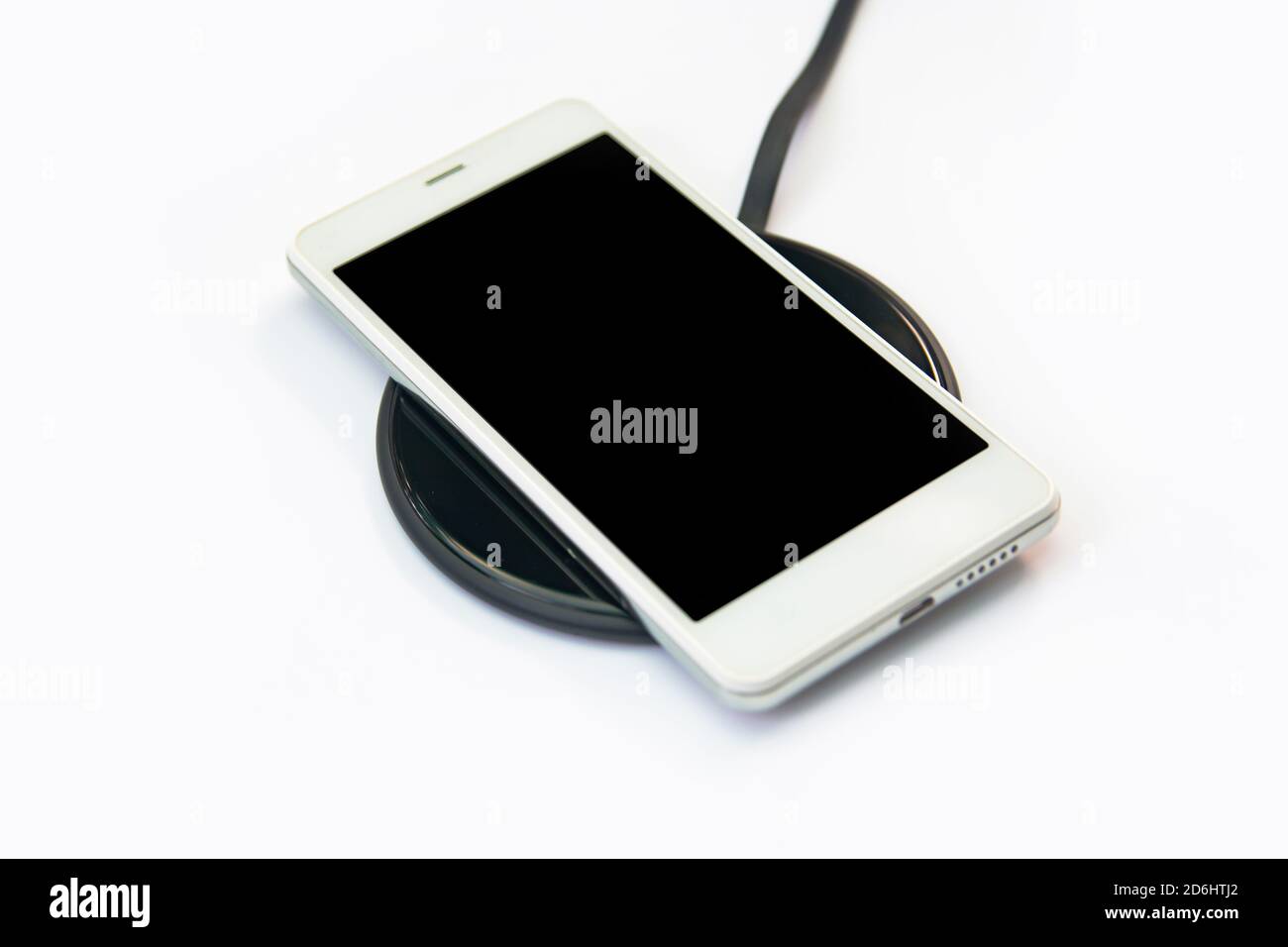 Smartphone charging on a wireless charger on white background. black ...