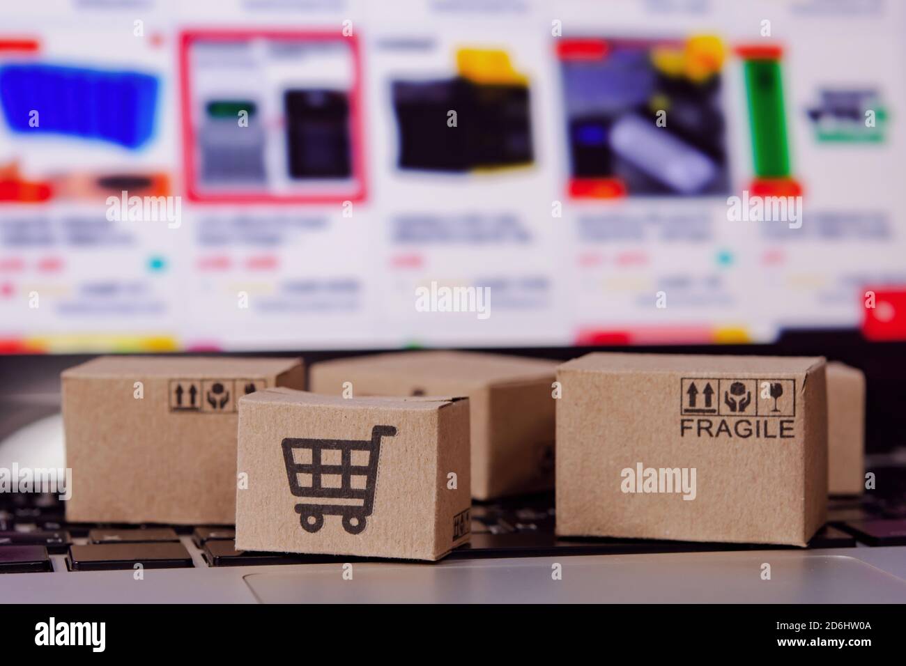 Shopping online. Cardboard box with a shopping cart logo on laptop ...