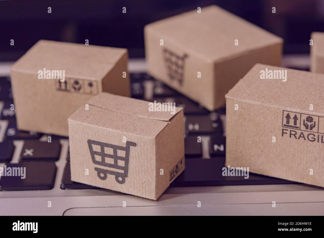 Shopping online. Cardboard box with a shopping cart logo on laptop ...