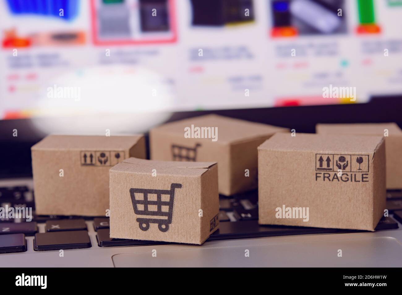 Shopping online. Cardboard box with a shopping cart logo on laptop ...