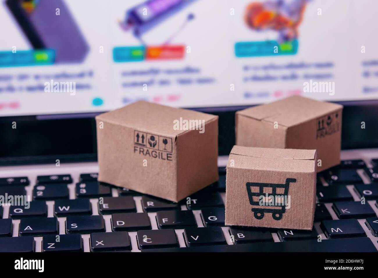 Shopping online. Cardboard box with a shopping cart logo on laptop ...