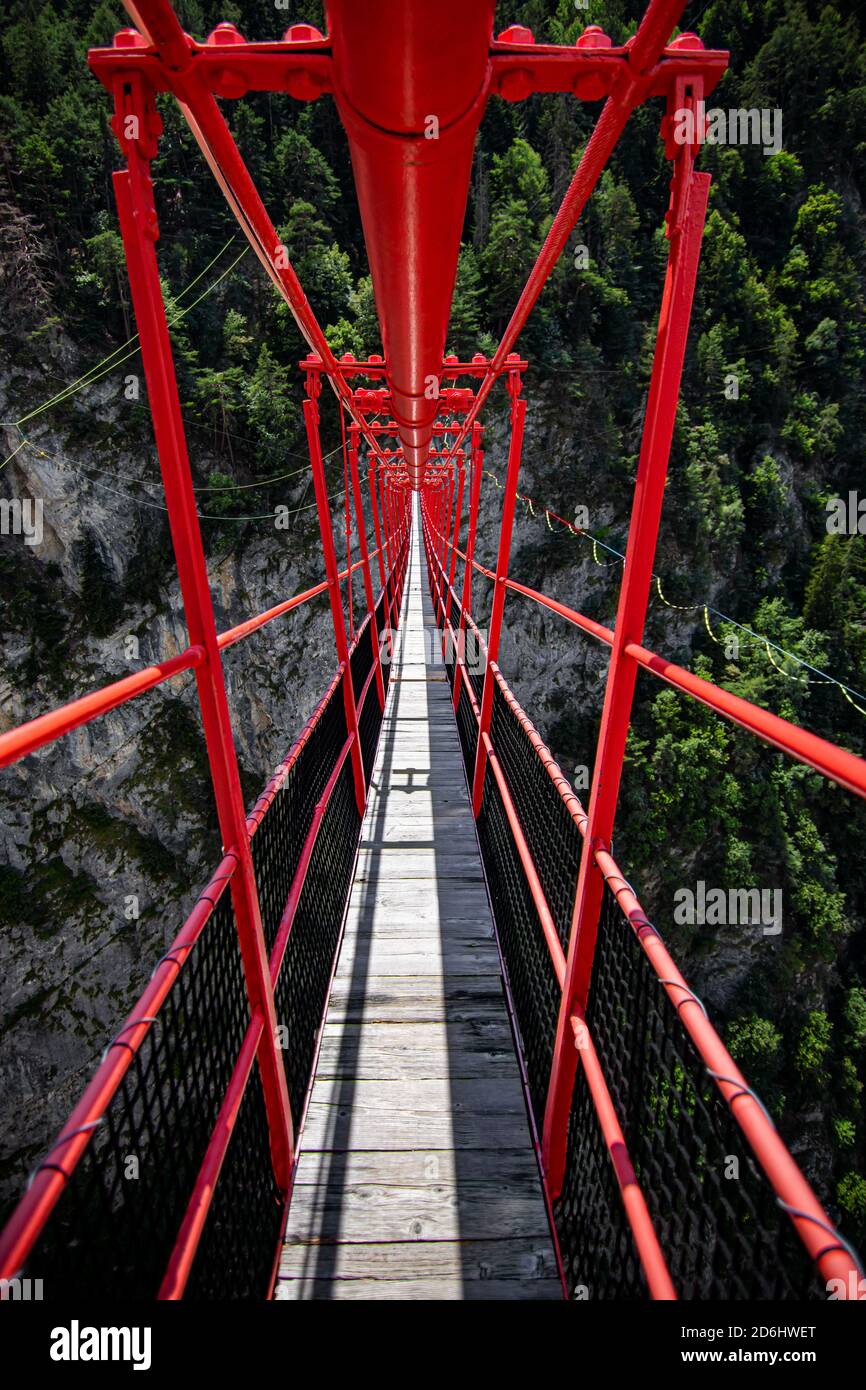 Wooden long footbridge above the deep gorge with a river beach at the ...