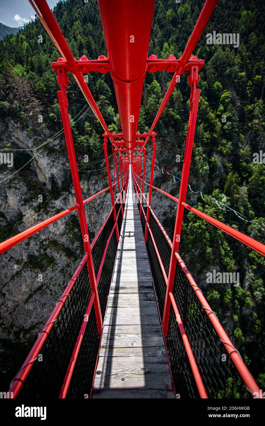 Wooden long footbridge above the deep gorge with a river beach at the ...