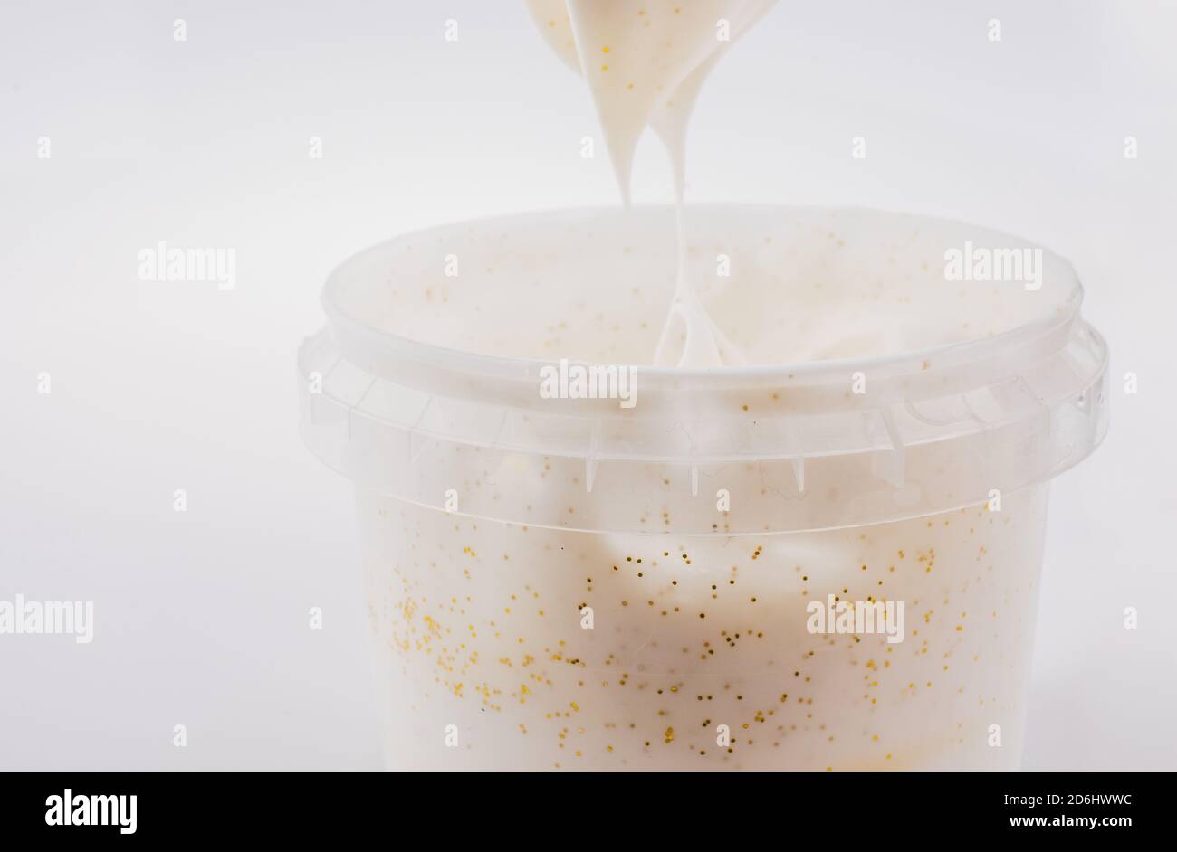Closeup shot of textured beige cream being scooped out a container ...