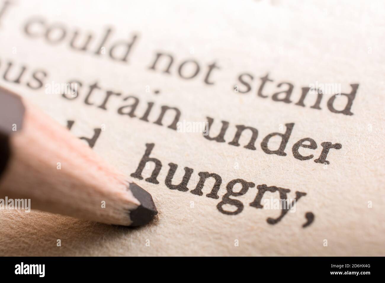 Closeup shot of a pencil pointing at the word hungry in a text Stock ...