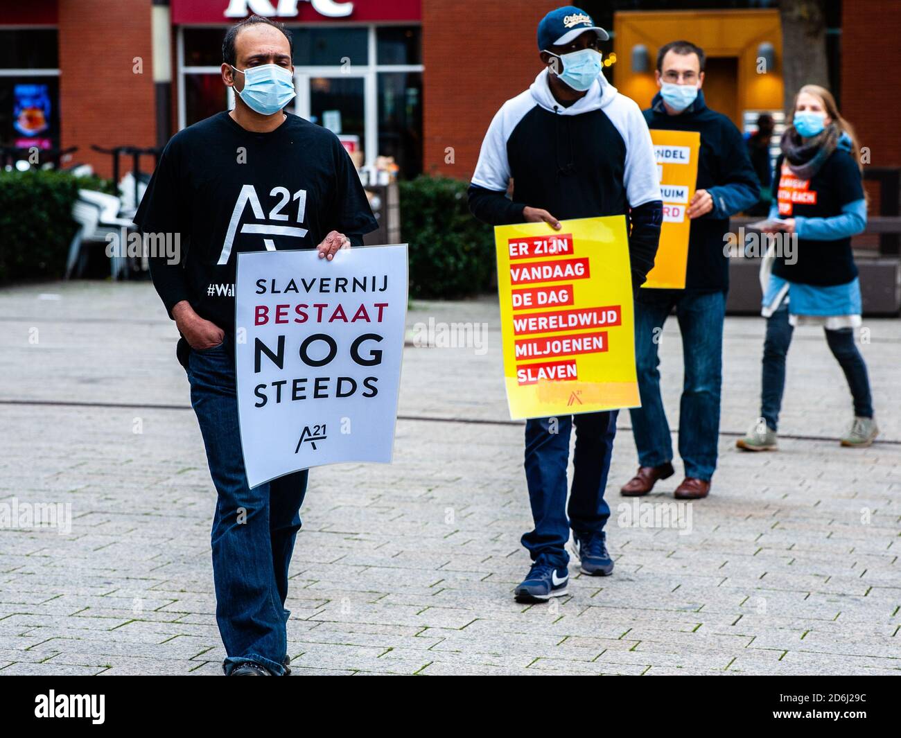 A group of activists are seen walking in circles while holding placards ...