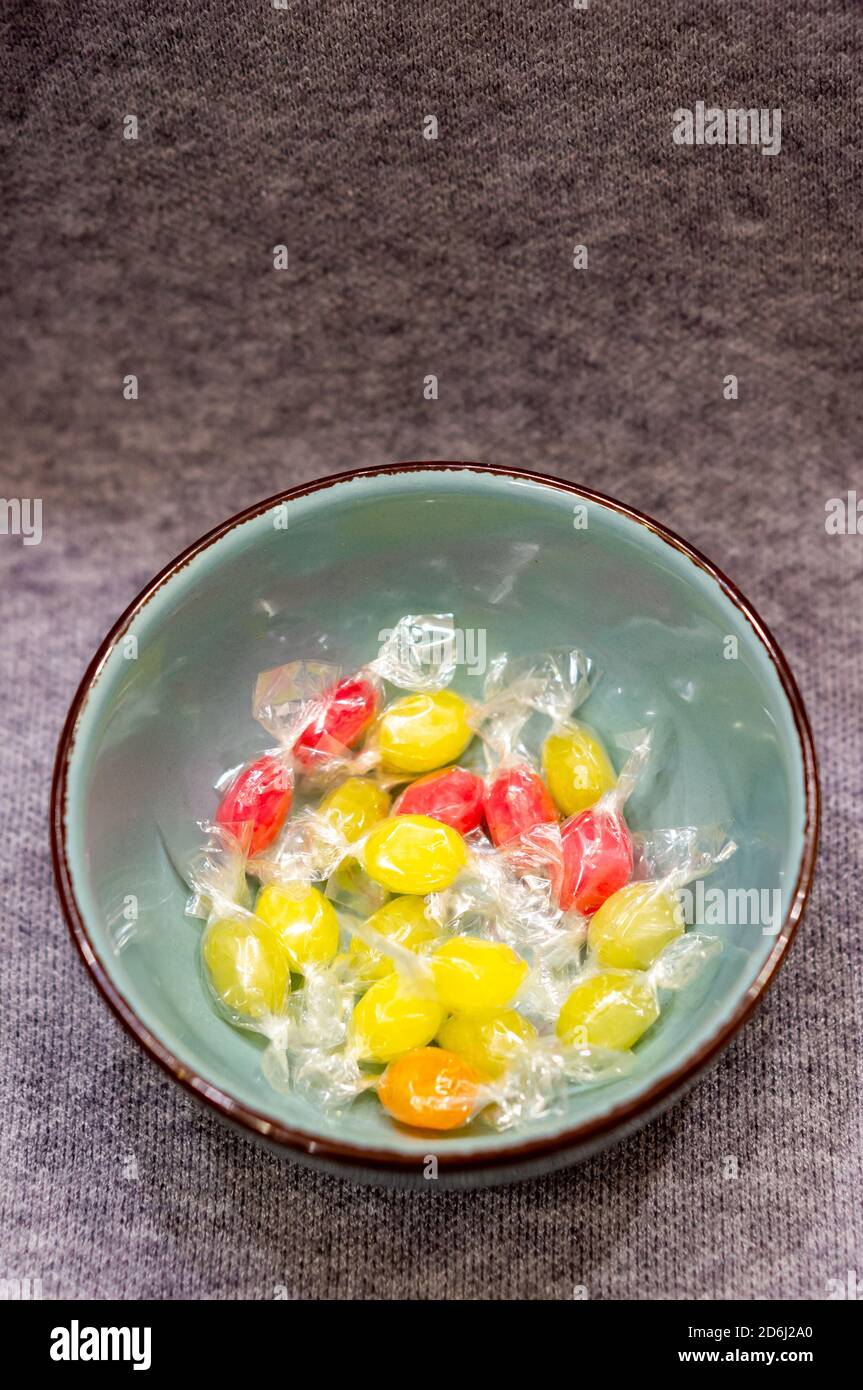 Vertical high angle shot of a ceramic bowl filled with colorful hard ...