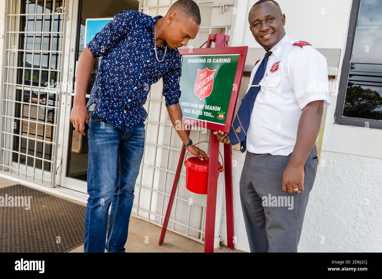 A Man Dropping Money In The Salvation Army Bucket Stock Photo - Alamy