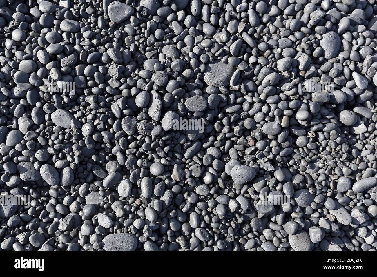 Rounded black stones, lava pebbles, background image, beach ...