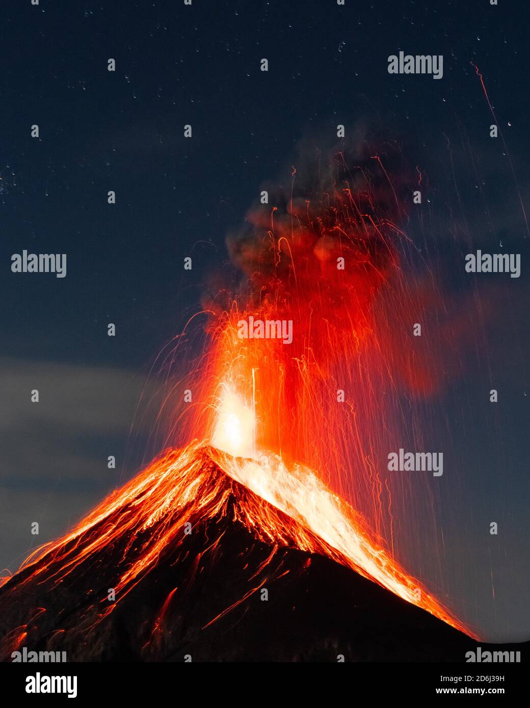 Glowing lava and smoke spitting volcano, volcanic eruption at night ...