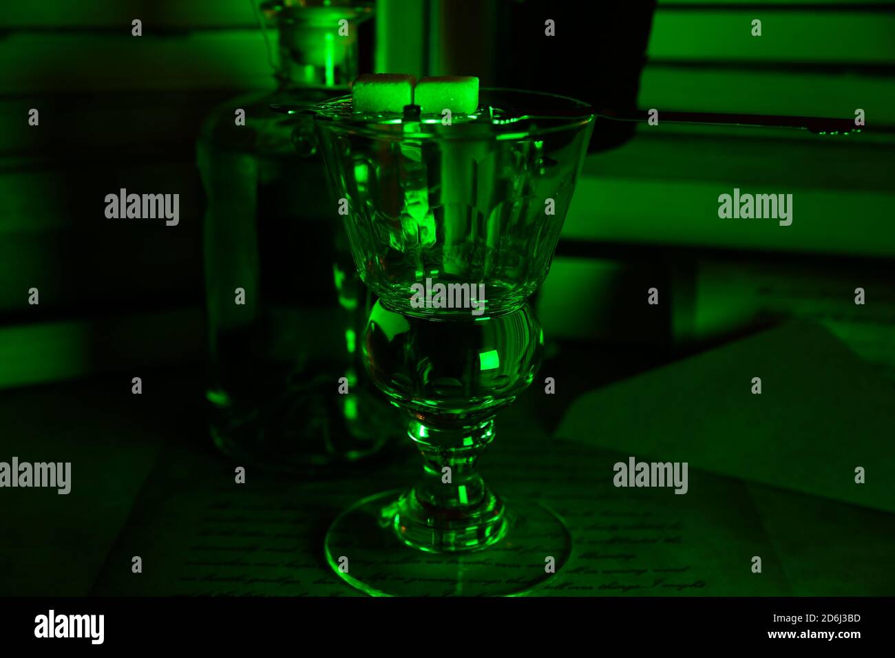 View on isolated absinth glass and bottle in gloomy green night ...