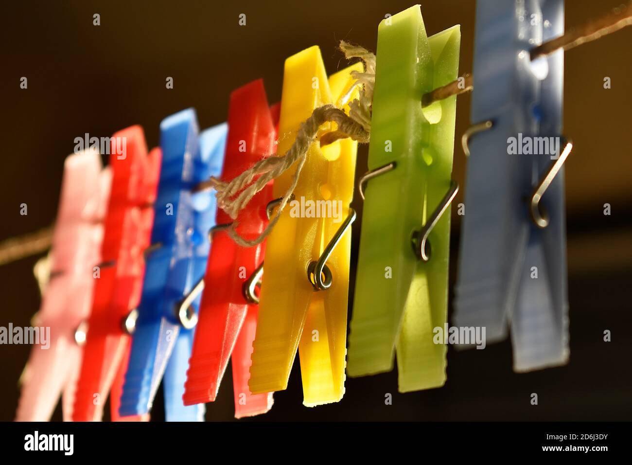 Colorful clothes pegs. Clothes pins hanging on a clothes line rope ...