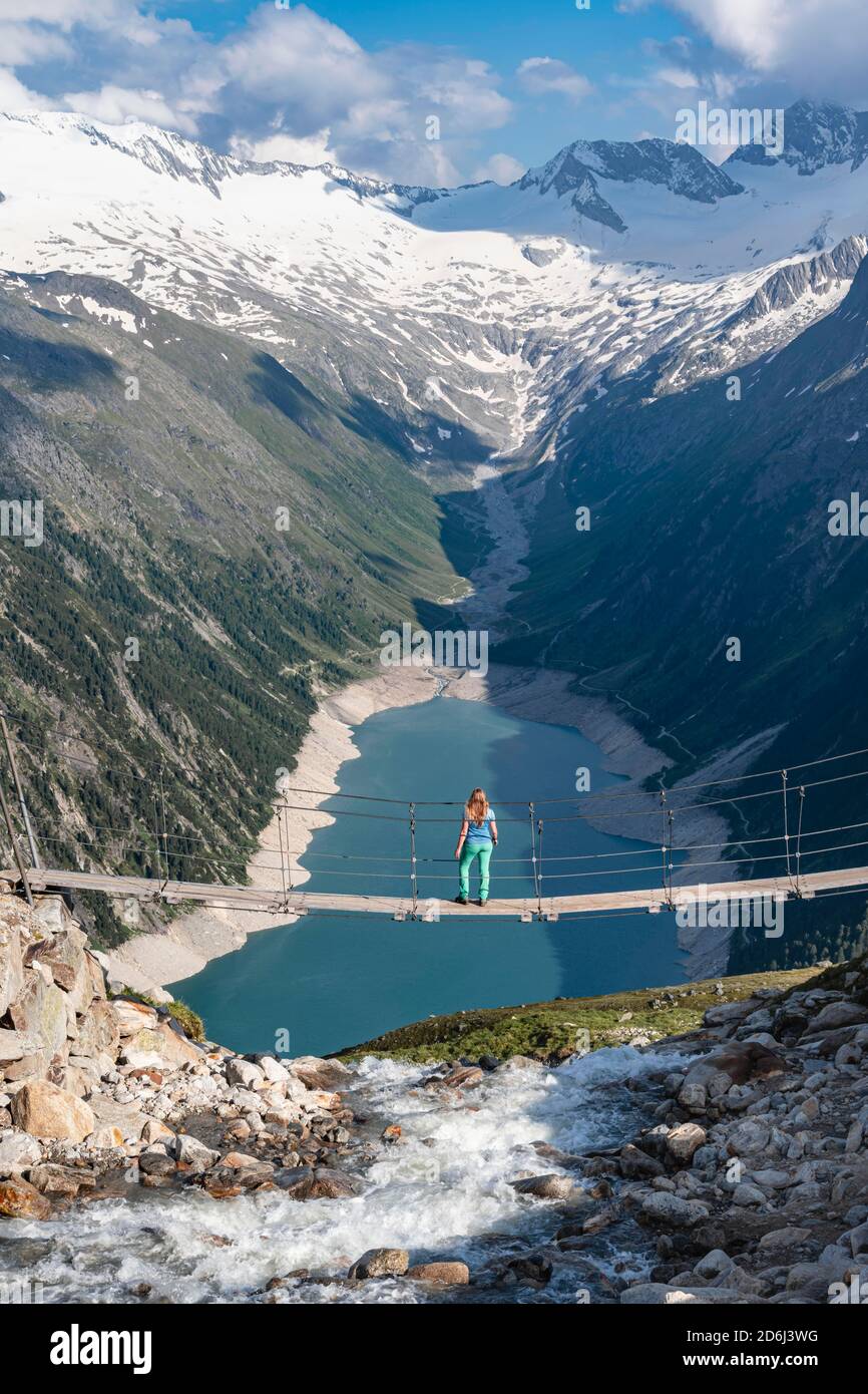 Hiker, woman on suspension bridge at the Olpererhuette, Schlegeis ...