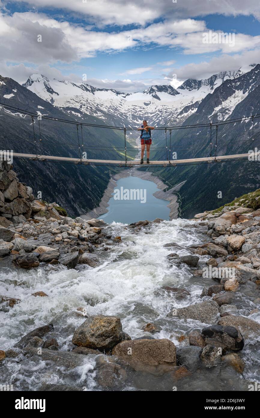 Hiker, woman on suspension bridge at the Olpererhuette, Schlegeis ...