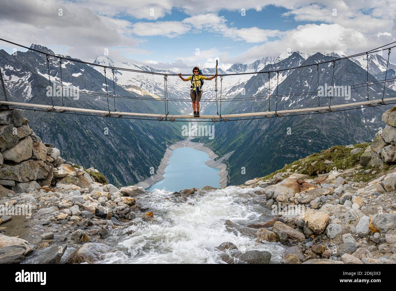 Hiker, woman on suspension bridge at the Olpererhuette, Schlegeis ...