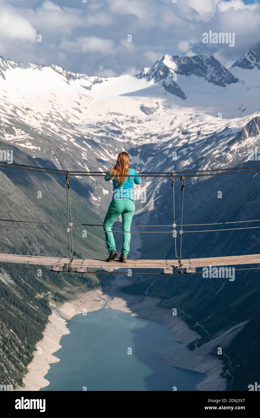 Hiker, woman on suspension bridge at the Olpererhuette, Schlegeis ...