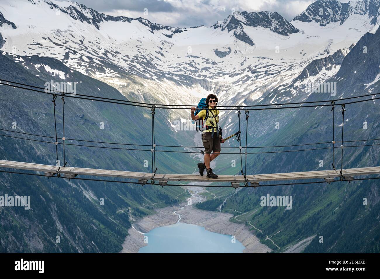 Hiker, woman on suspension bridge at the Olpererhuette, Schlegeis ...