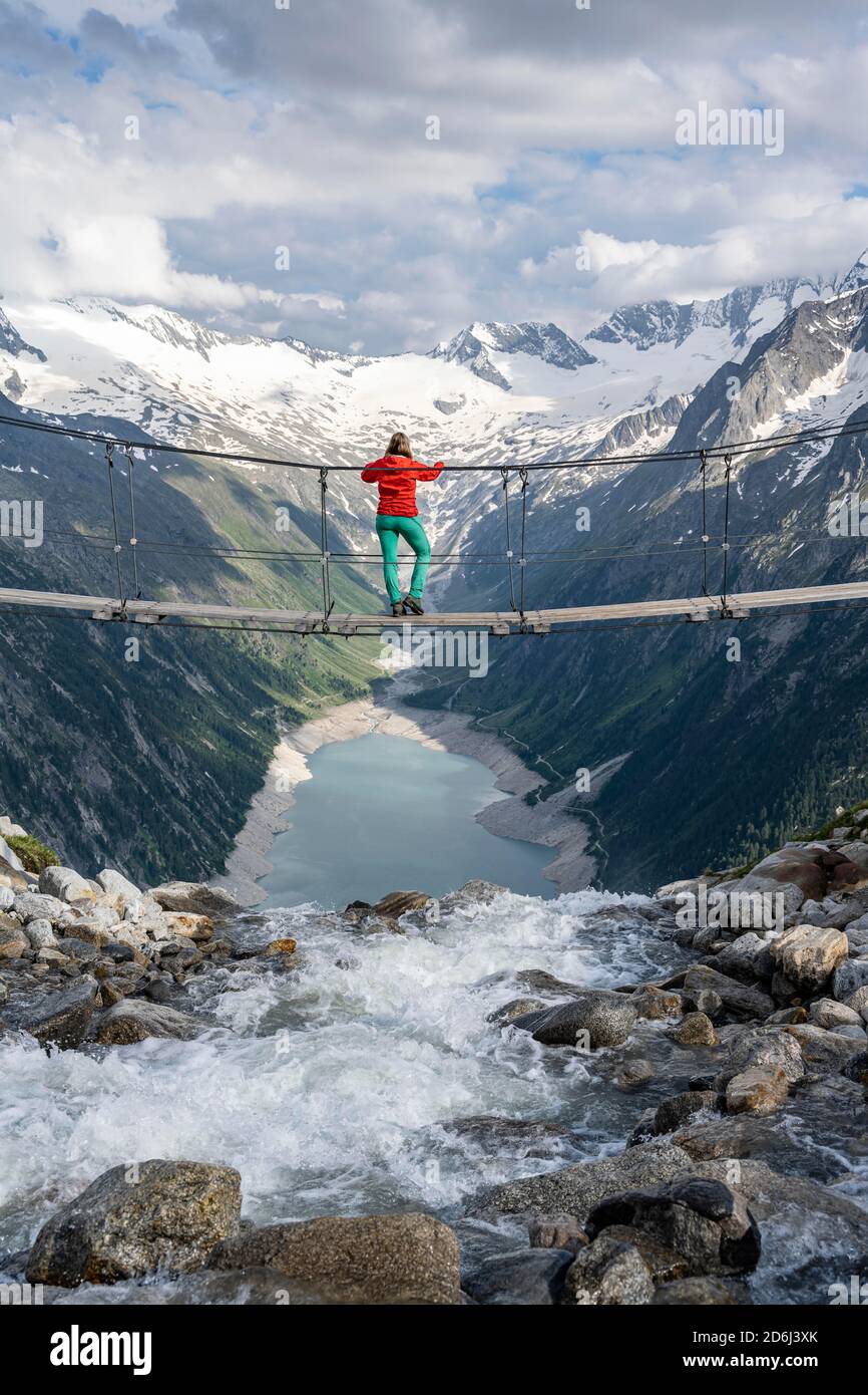 Hiker, woman on suspension bridge at the Olpererhuette, Schlegeis ...