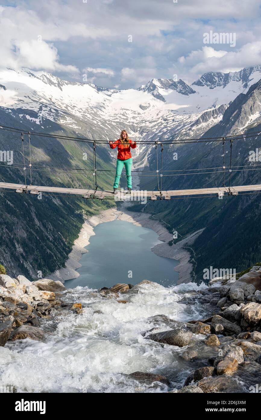 Hiker, woman on suspension bridge at the Olpererhuette, Schlegeis ...