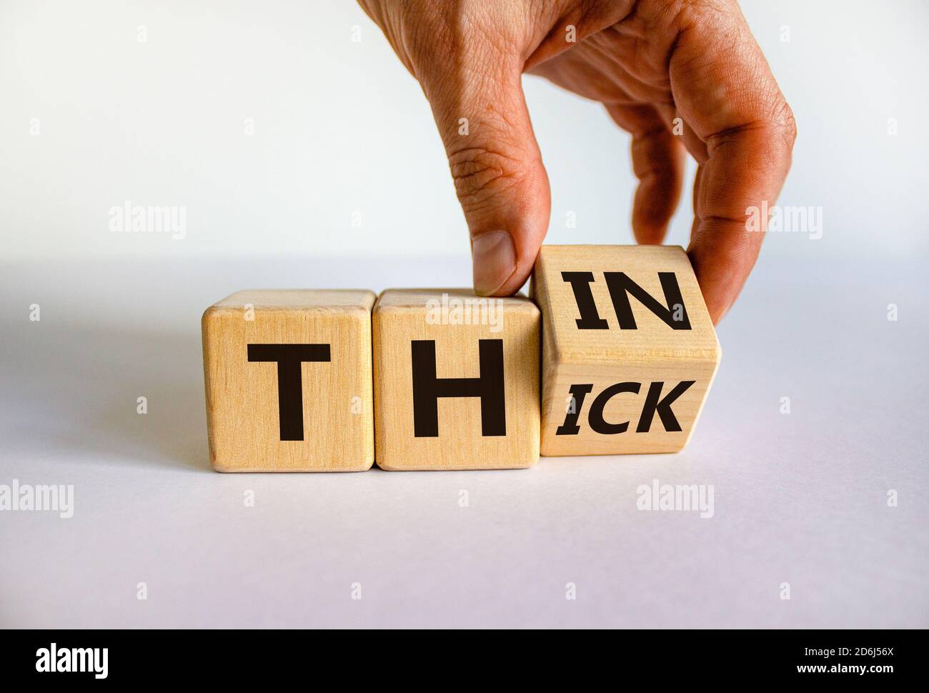 Hand flips a cube and changes the word 'thick' to 'thin' or vice versa ...