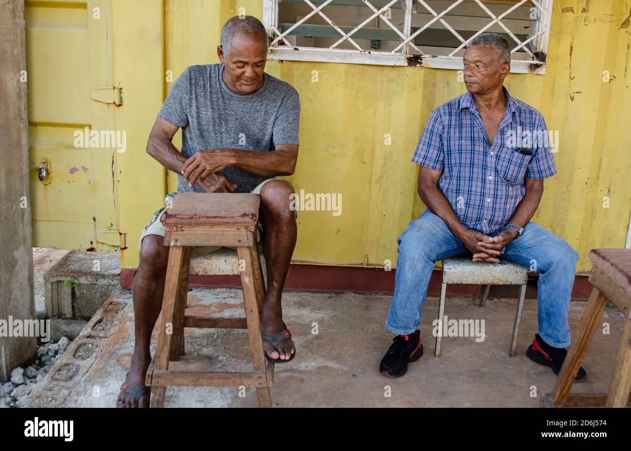 Men Sitting Outside A Shop Stock Photo - Alamy