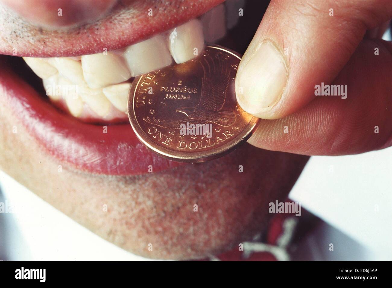 Man bites into dollar coin hi-res stock photography and images - Alamy