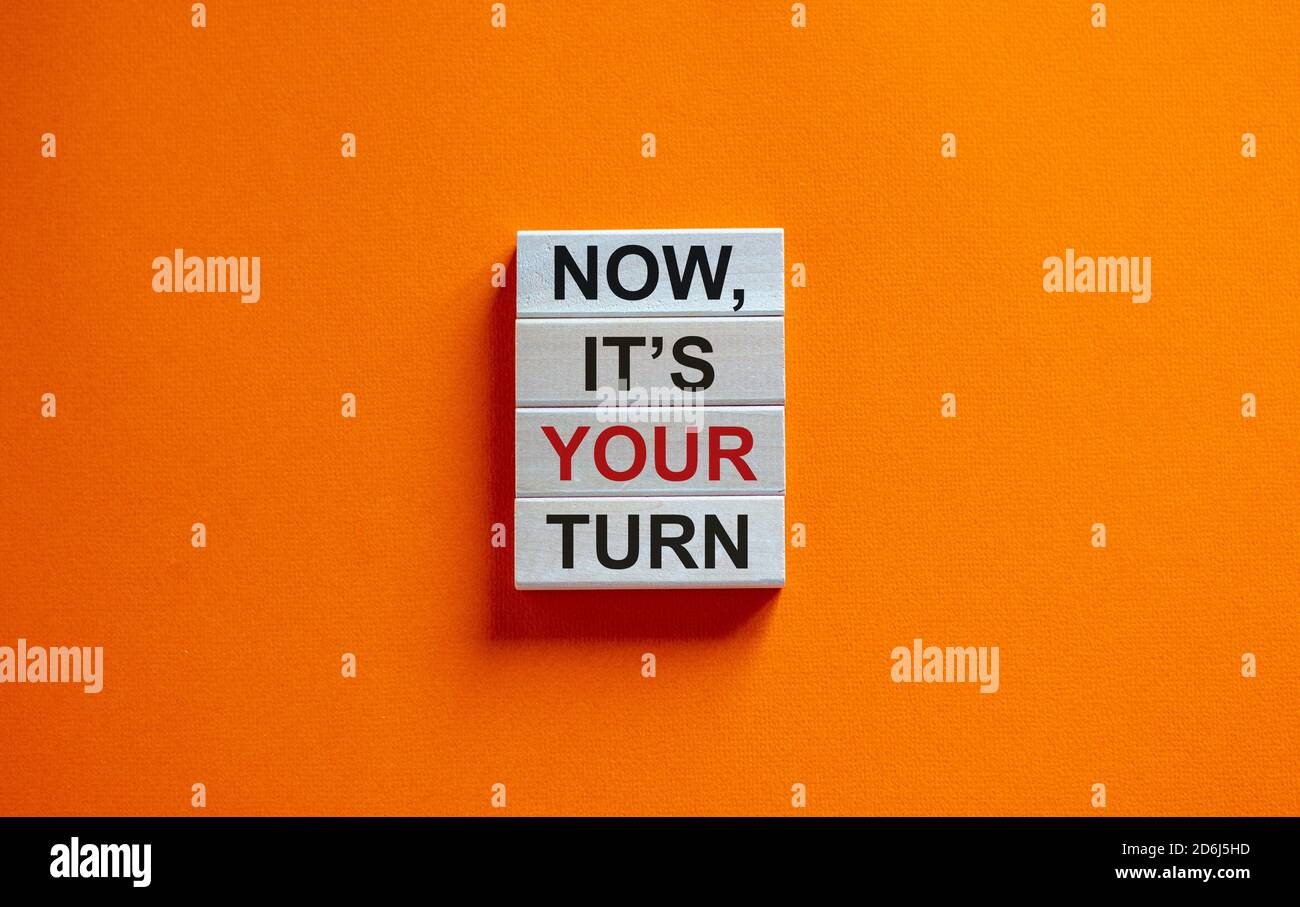 Wooden blocks form the words 'now, its your turn' on beautiful orange ...