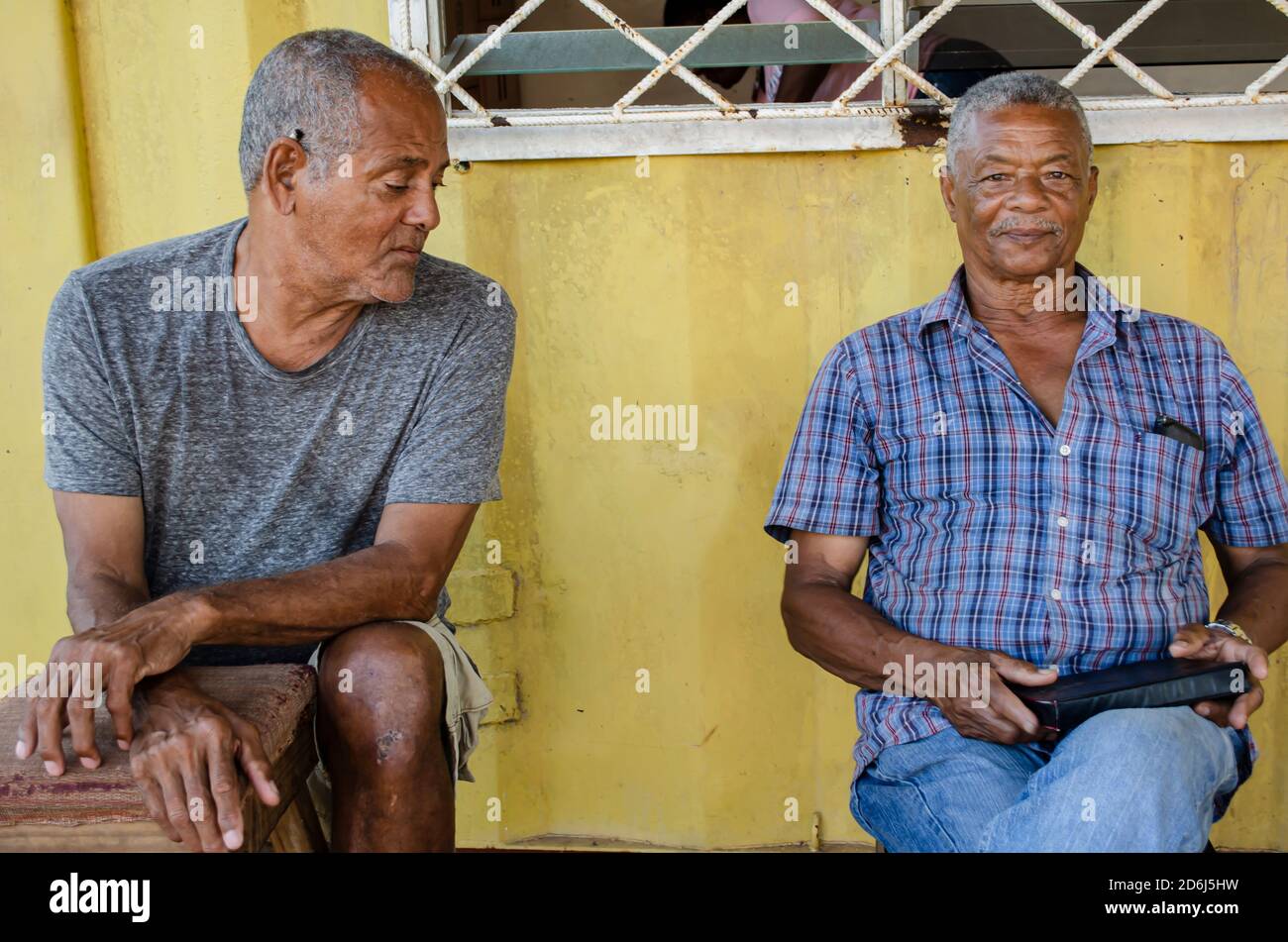 Men Sitting Outside A Shop Stock Photo - Alamy