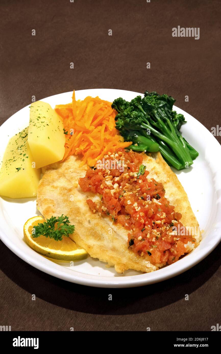 grilled fish fillet with chopped tomatoes, potatoes and vegetables ...