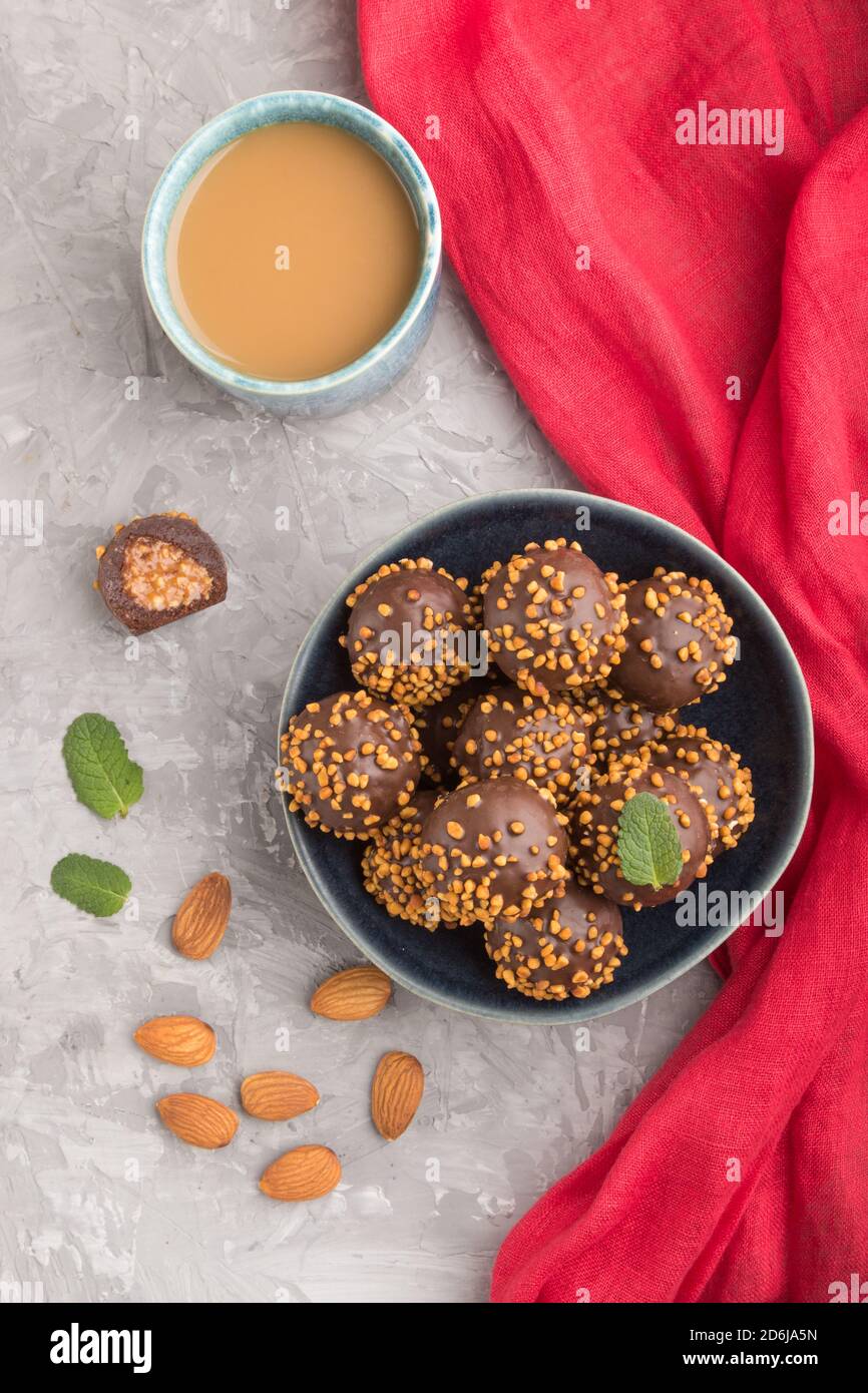 Chocolate caramel ball candies with almonds and a cup of coffee on a ...