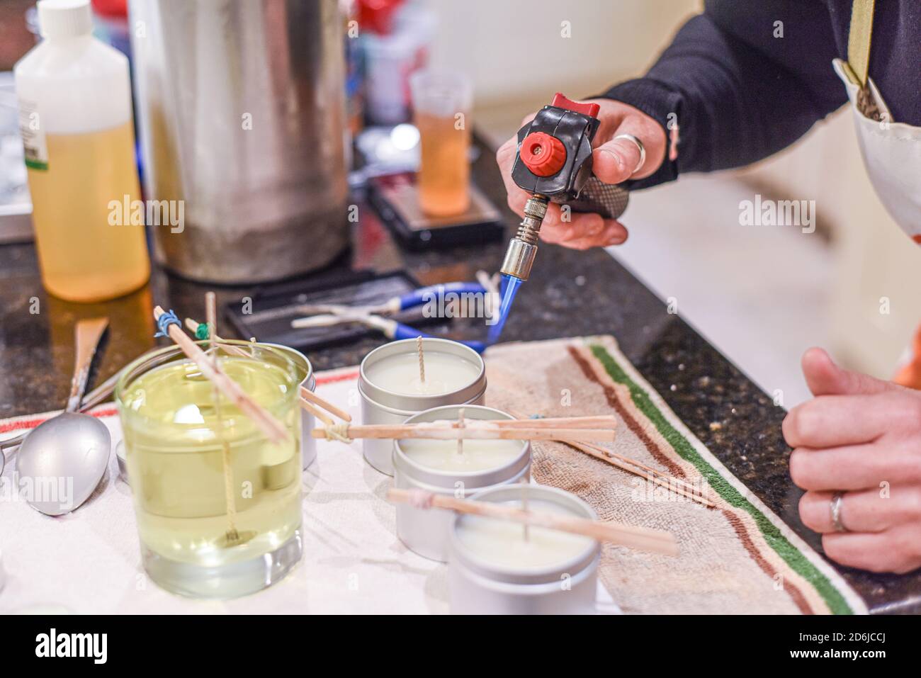 Creative occupation of candle making showing the pouring of liquid wax ...