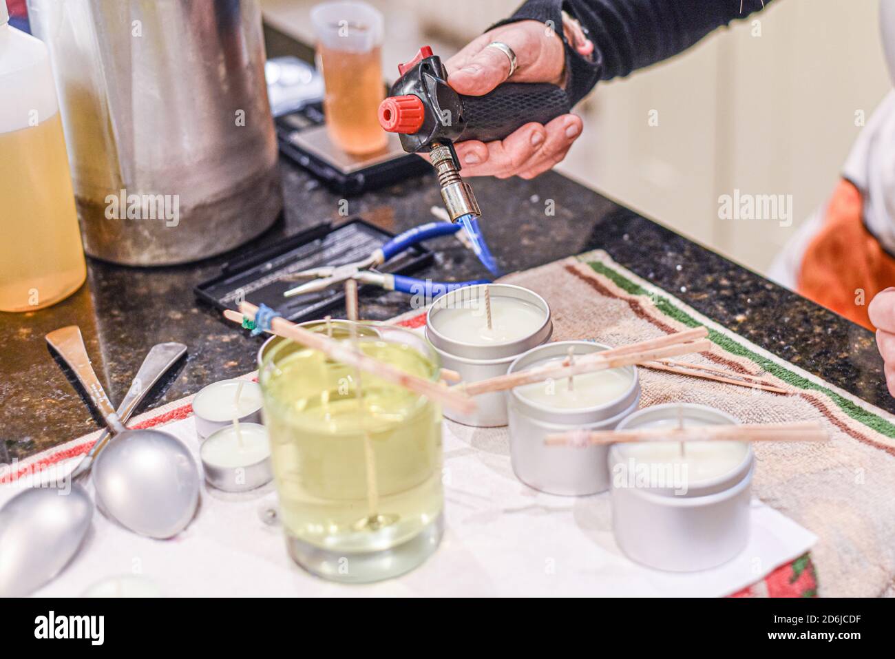 Creative occupation of candle making showing the pouring of liquid wax ...