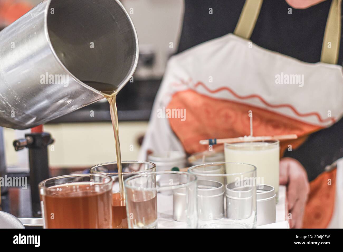 Creative occupation of candle making showing the pouring of liquid wax ...