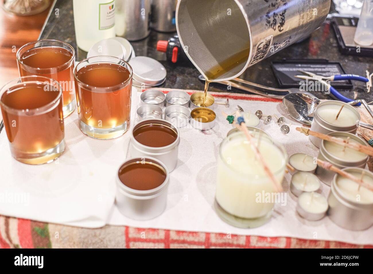 Creative occupation of candle making showing the pouring of liquid wax ...