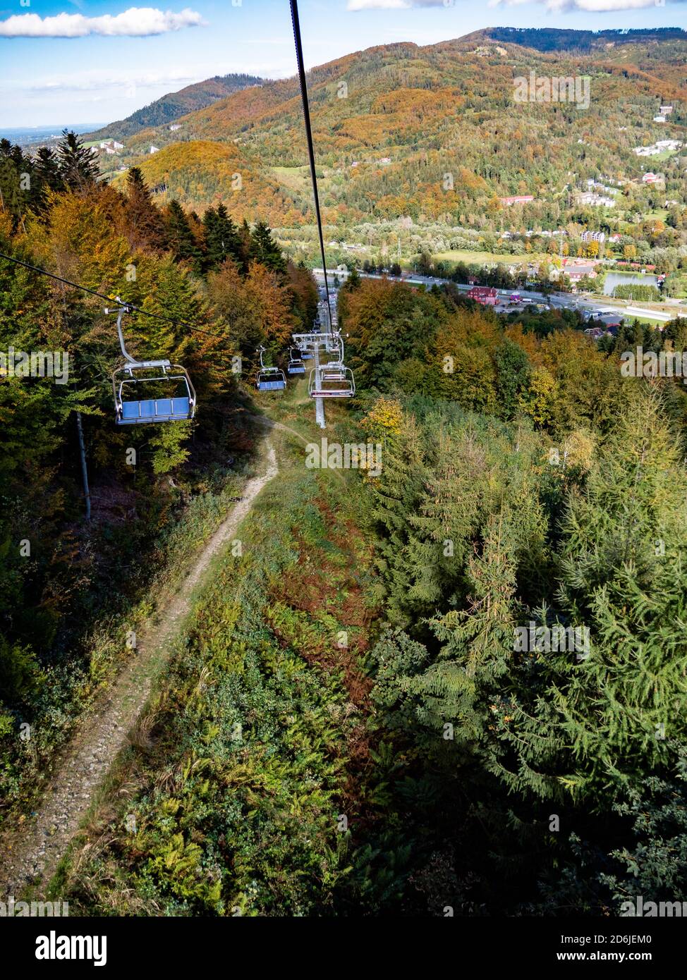 Aerial vertical shot of cable cars over mountain landscape with autumn ...