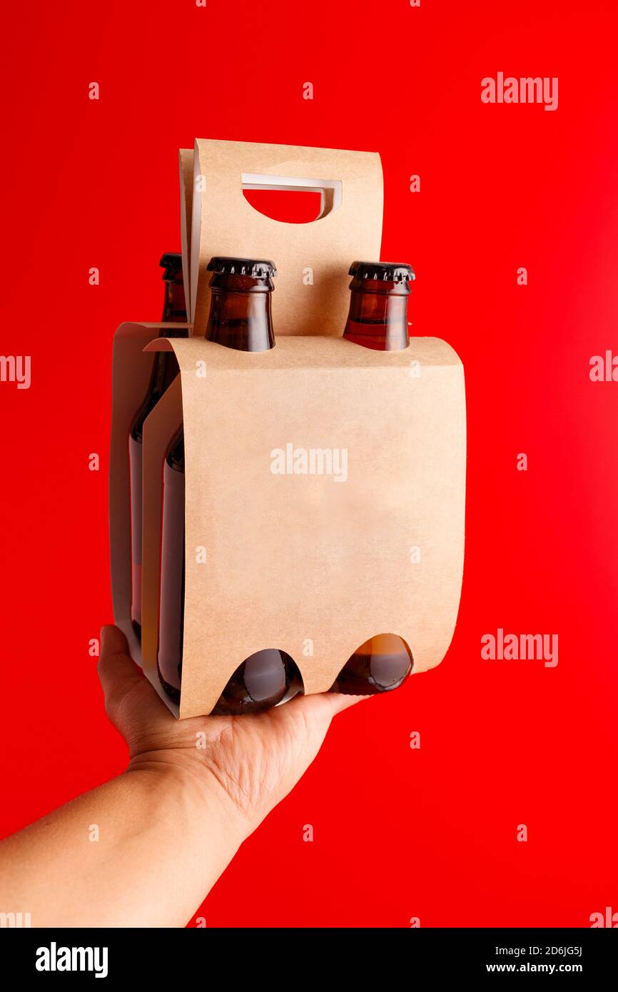 Hand holding a four pack beer presentation with red background Stock ...