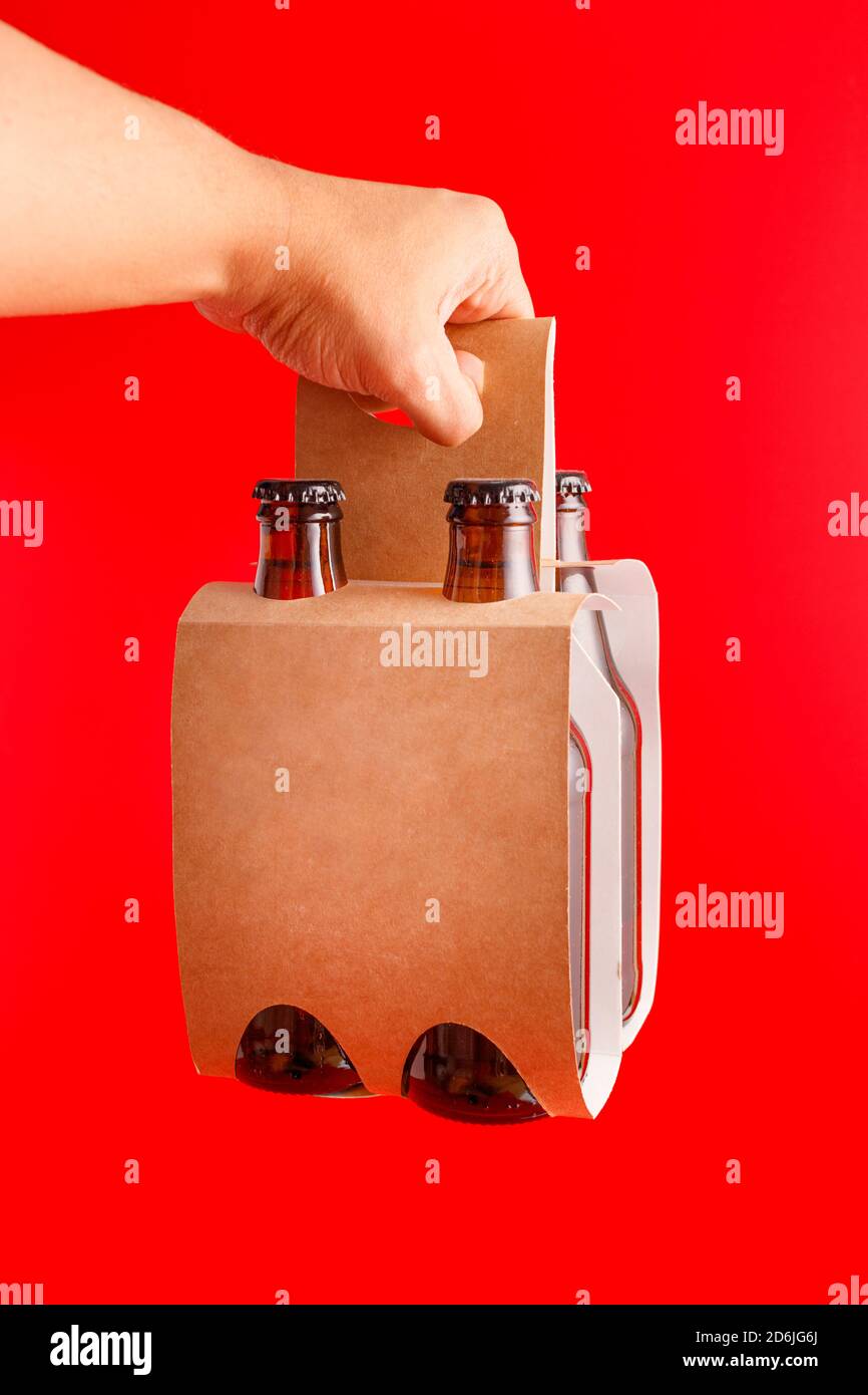 Hand holding a four pack beer presentation with red background Stock ...