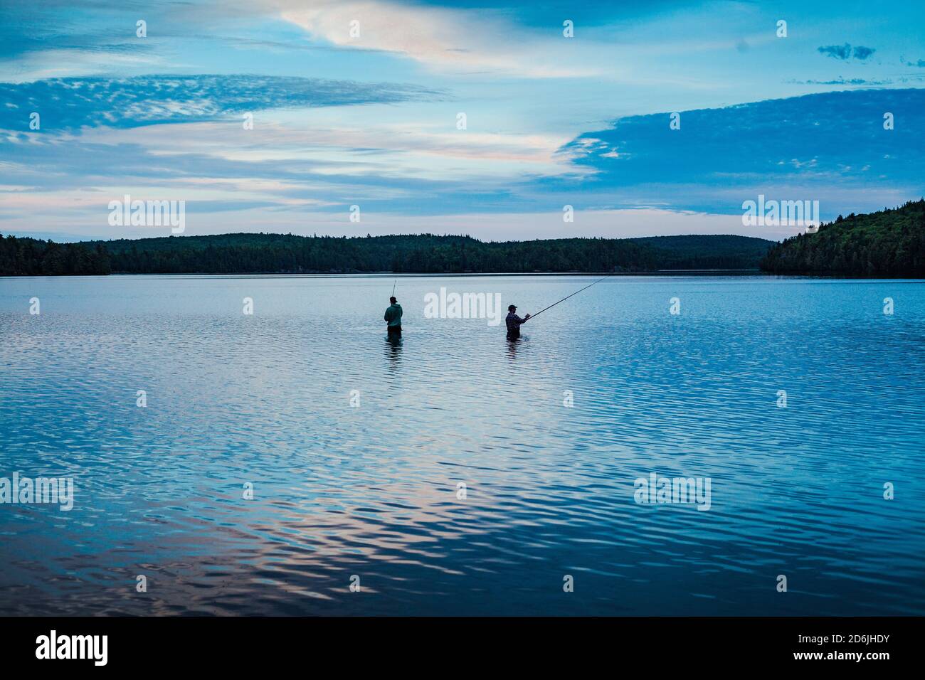 Two men fishing in a calm lake Stock Photo - Alamy