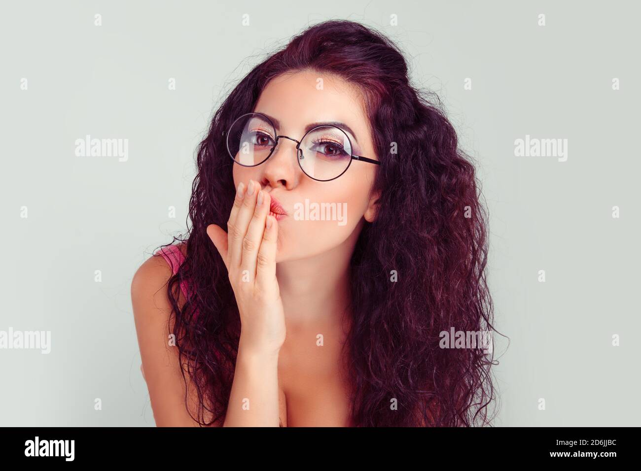 Blowing a virtual kiss. Adorable young model with curly long hairstyle ...