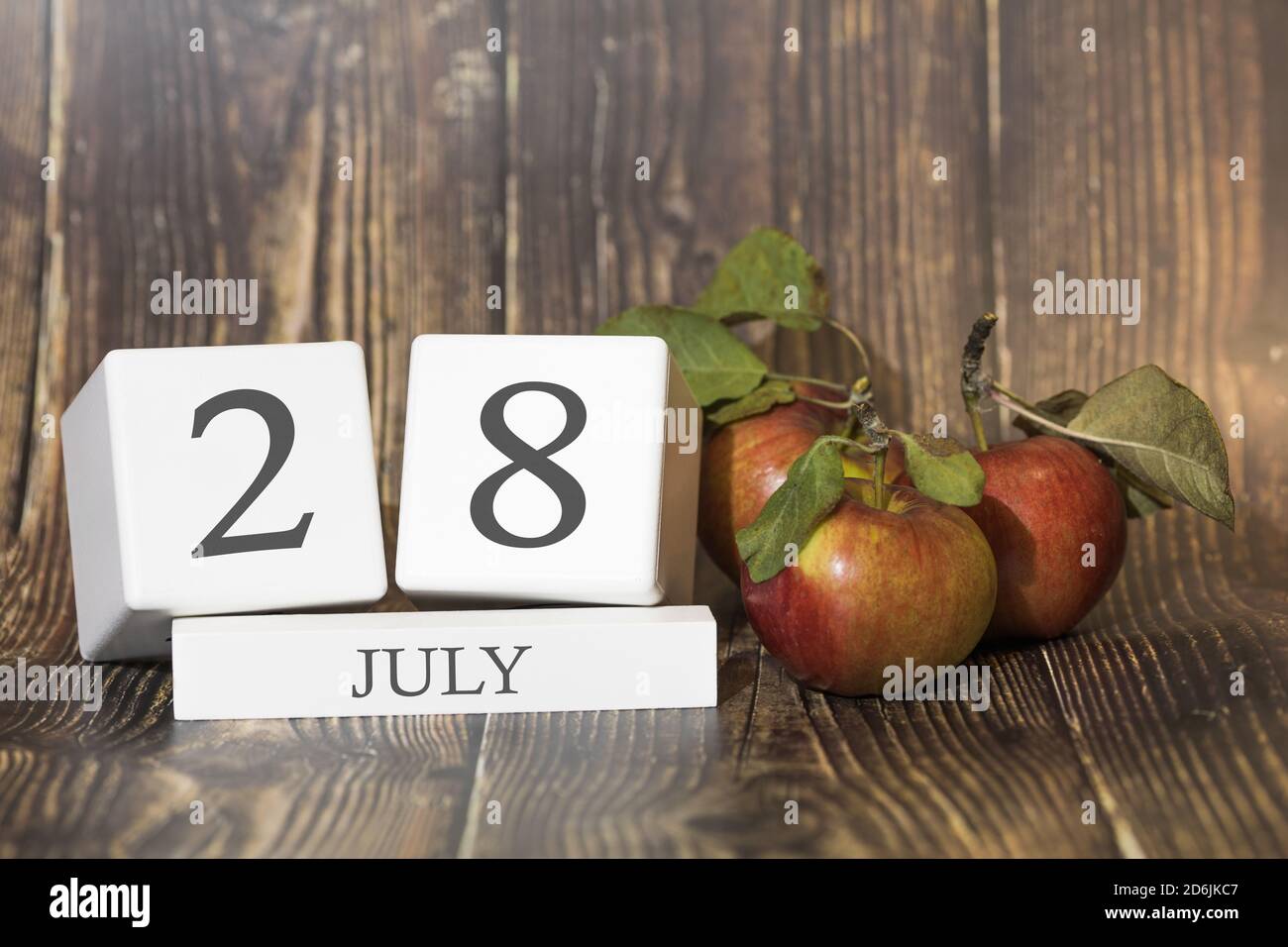 July 28. Day 28 of month. Calendar cube on wooden background with red ...