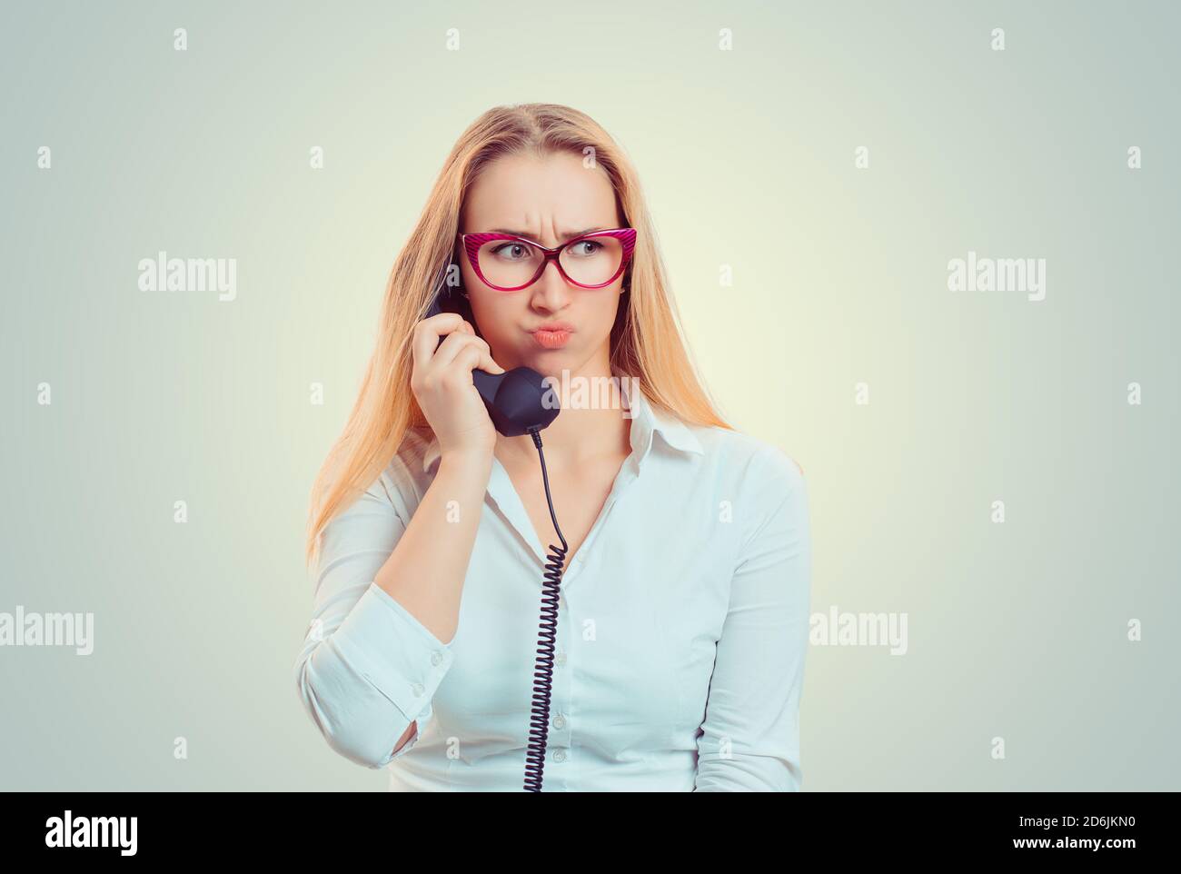 Serious grumpy frustrated woman having unpleasant phone call puckering ...